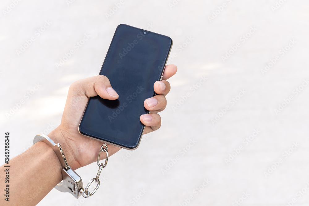 Smartphone chained to handcuffed in hand. Mobile phone addiction ...