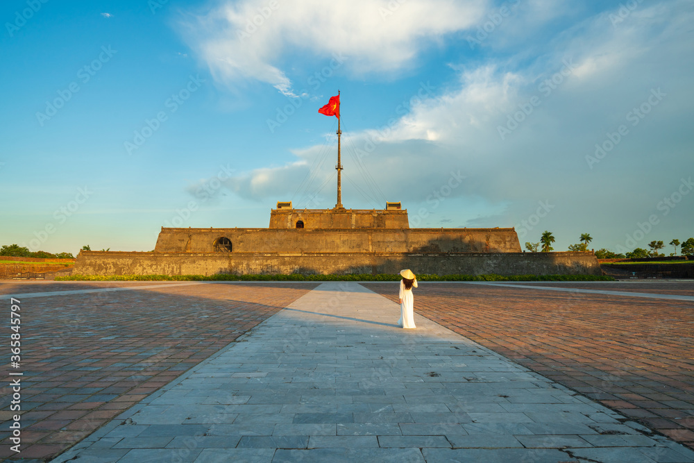 Ky Dai flag tower at Ngo Mon square with Vietnamese girl wearing ...