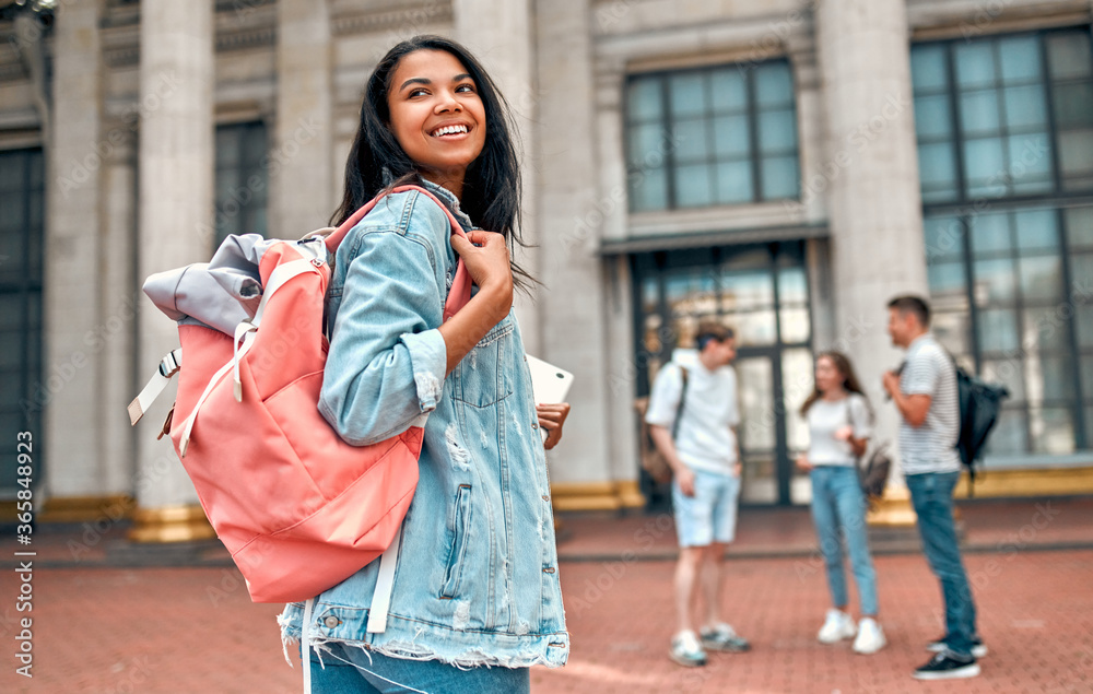 A cute African American girl student with a pink backpack and a laptop ...