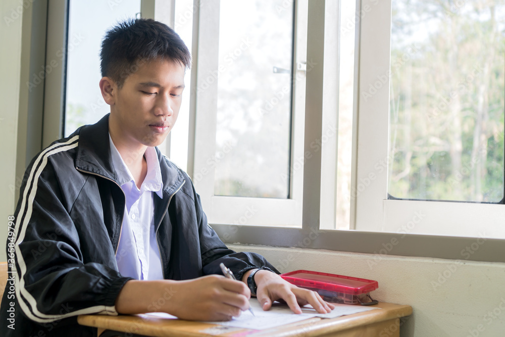 Asian Student young man testing in exercise taking exam paper answer ...
