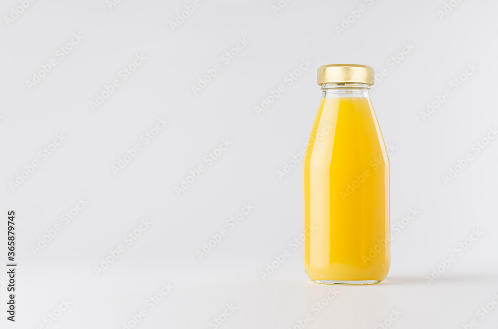 Orange yellow juice in glass bottle with gold cap mock up on white ...