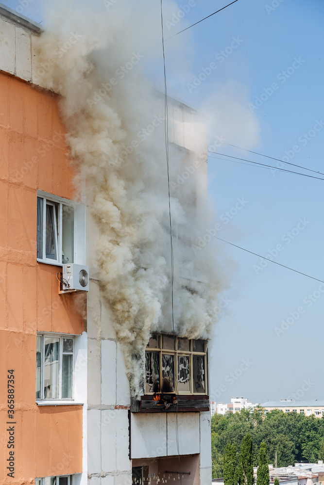fire on the balcony of a multi-storey building, black clouds of smoke ...