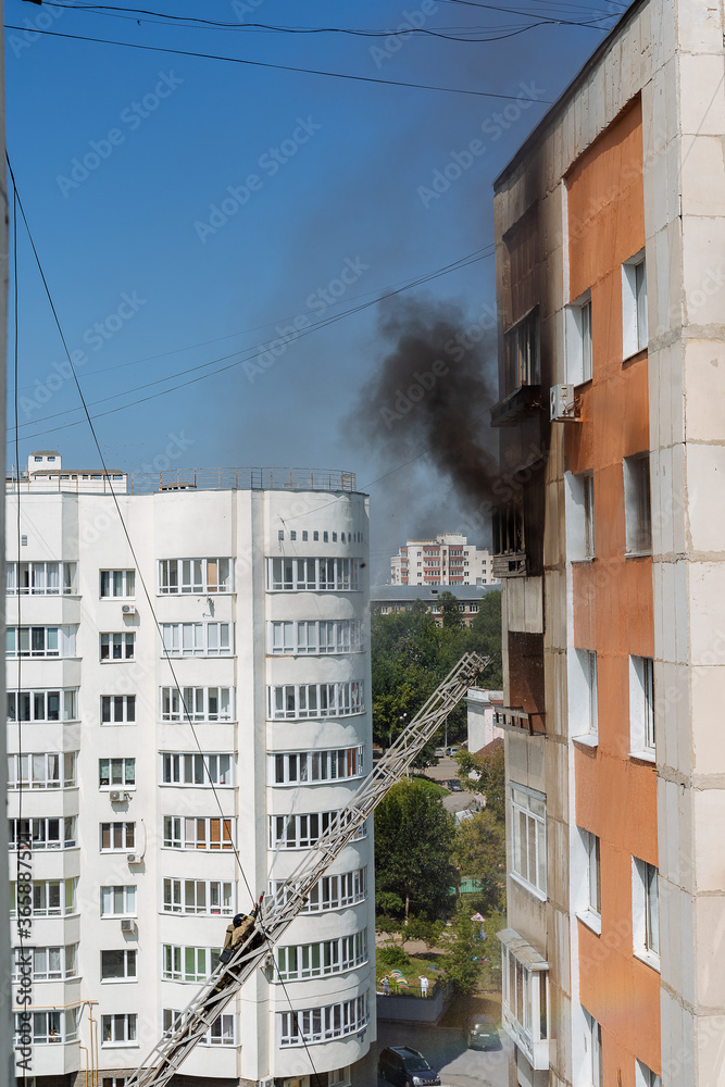 fire on the balcony of a multi-storey building, black clouds of smoke ...