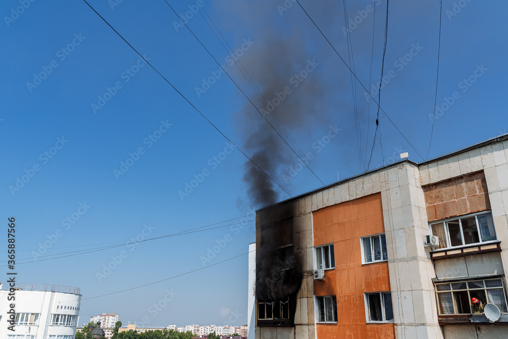fire on the balcony of a multi-storey building, black clouds of smoke ...