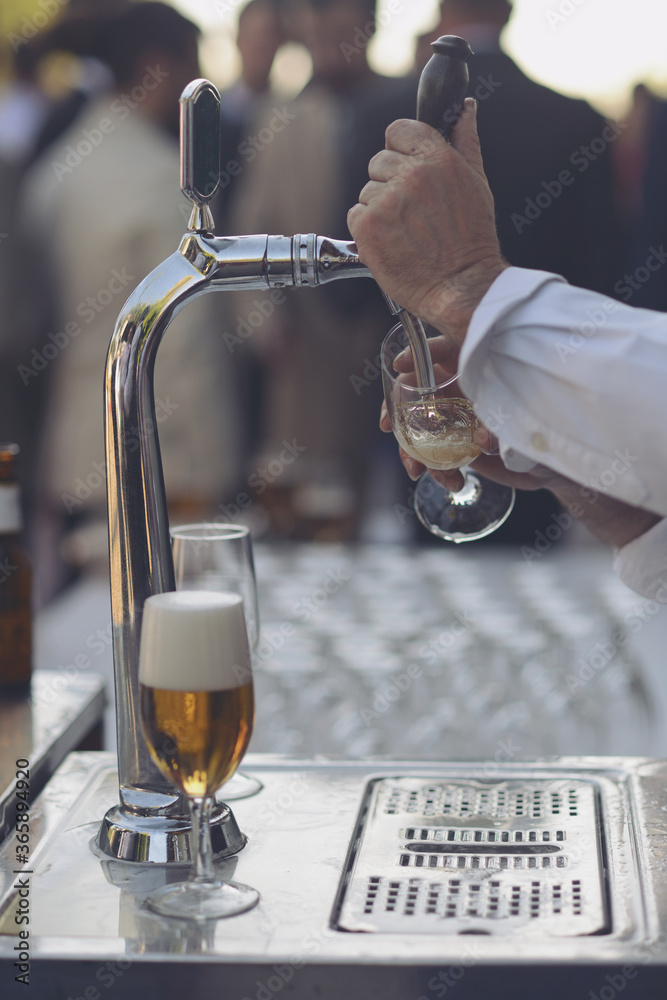 Waiter throwing beer on an open-air bar tap in vertical detail. Stock ...