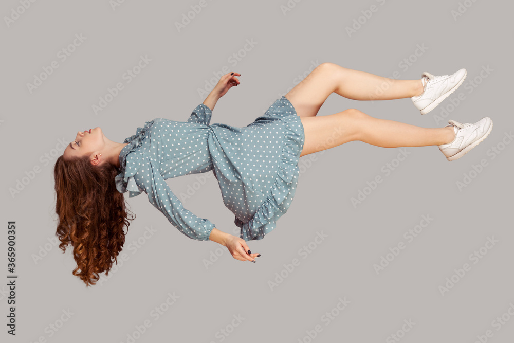 Floating in air. Relaxed girl in vintage ruffle dress levitating ...