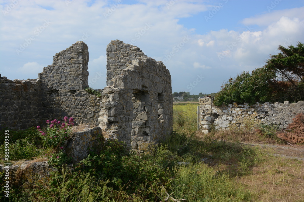 Derelict stone cottage on a beach with views across the the countryside ...