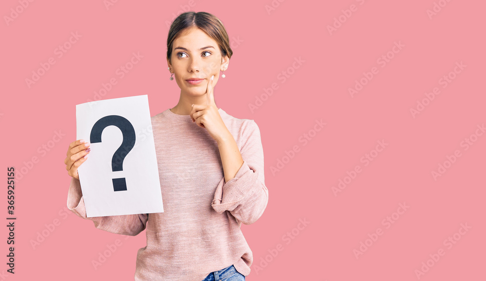 Beautiful caucasian woman with blonde hair holding question mark ...
