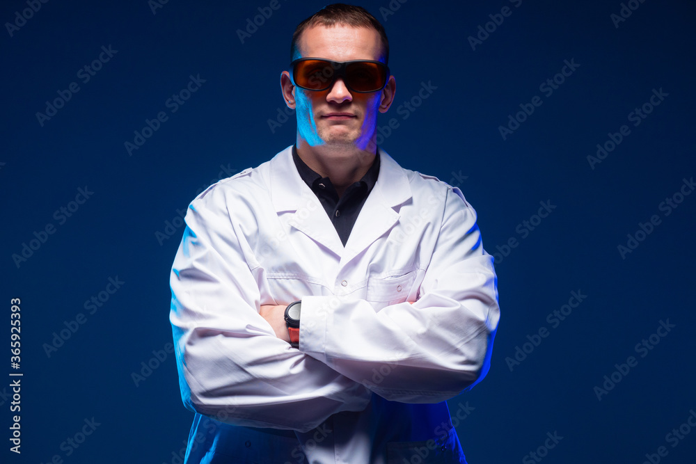 Doctor hero. A man in a medical gown stands with his arms crossed ...