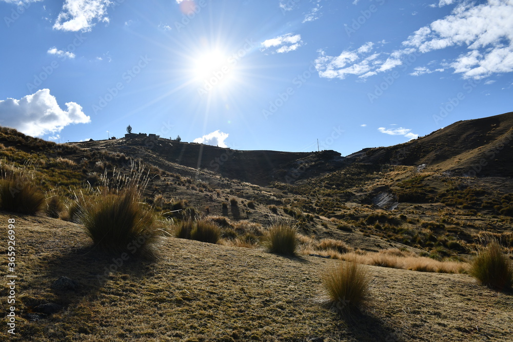 Stockfoto Bello paisaje andino panorámico con sol, ichu y pradera al ...