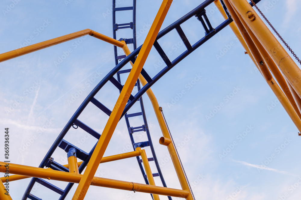 Low angle of under the roller coaster track against twilight sunset sky ...