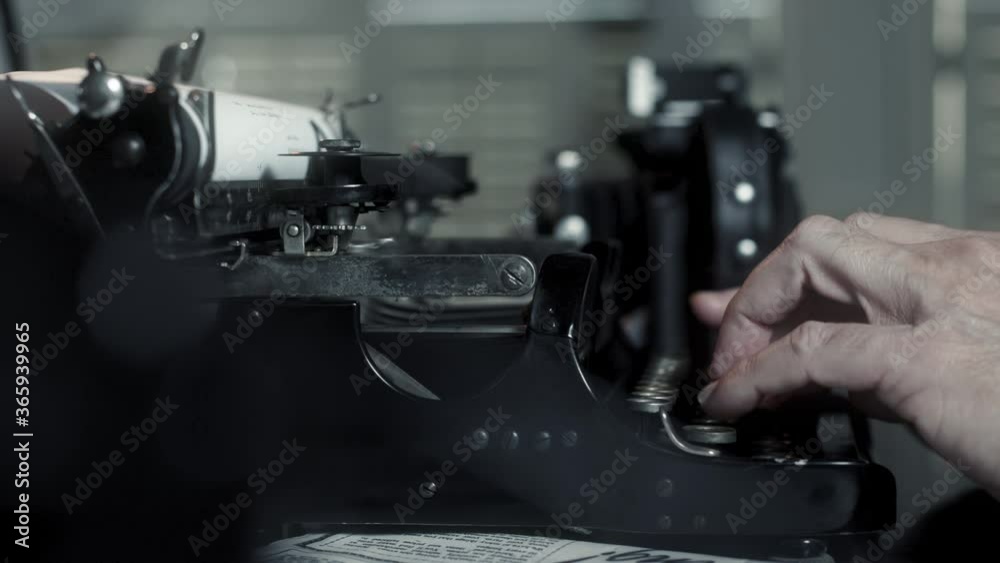 A 1940's era portable manual typewriter on which a man typing and with ...