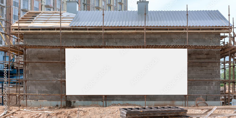 large white empty sign board on wall of temporary house on construction ...