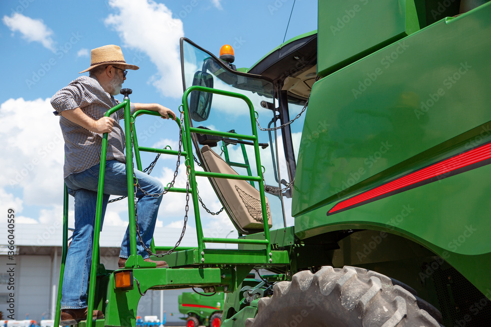 Professional farmer with a modern tractor at work process. Looks ...
