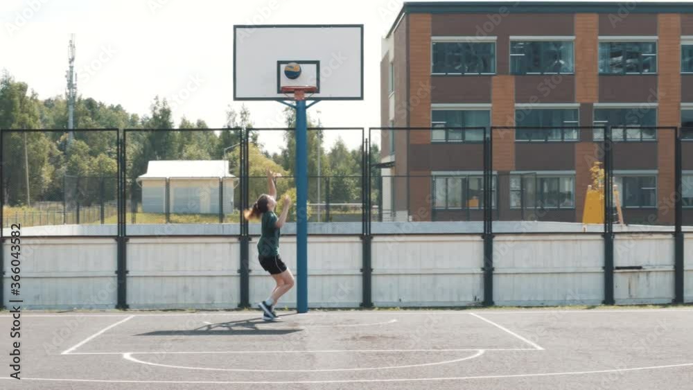Close up of female professional basketball player making slam dunk ...