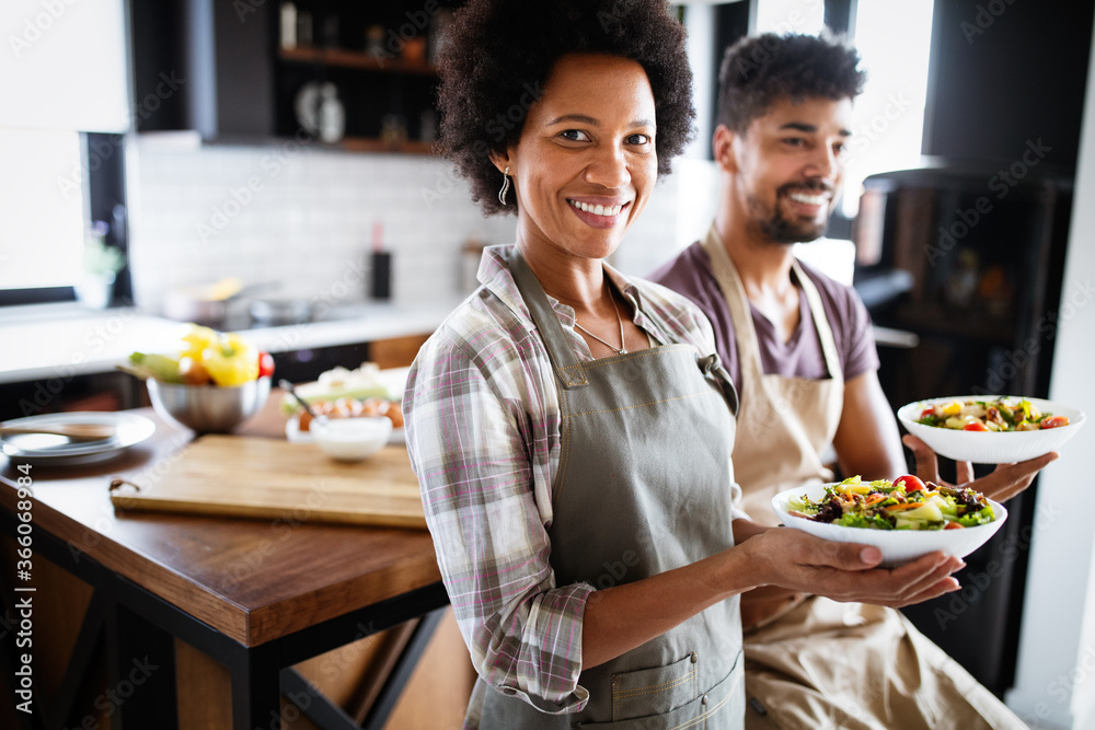 Beautiful young couple cooking healthy food together at home. Having ...