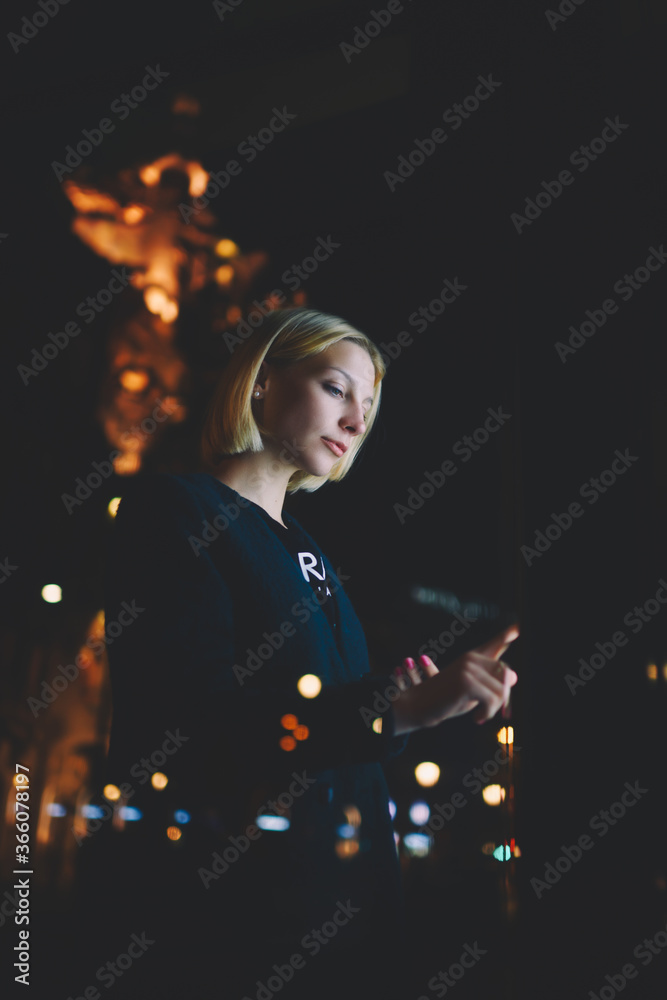 Half length portrait of a young blonde woman standing front big digital ...