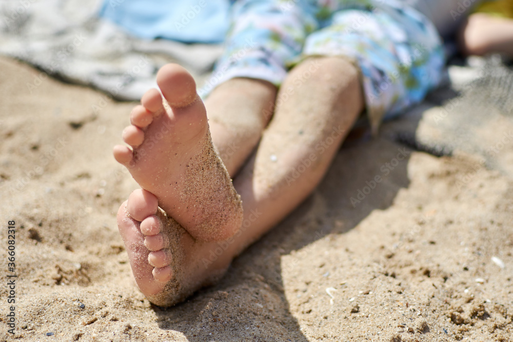 Feet of a child in the sand on the beach. The concept of carelessness ...