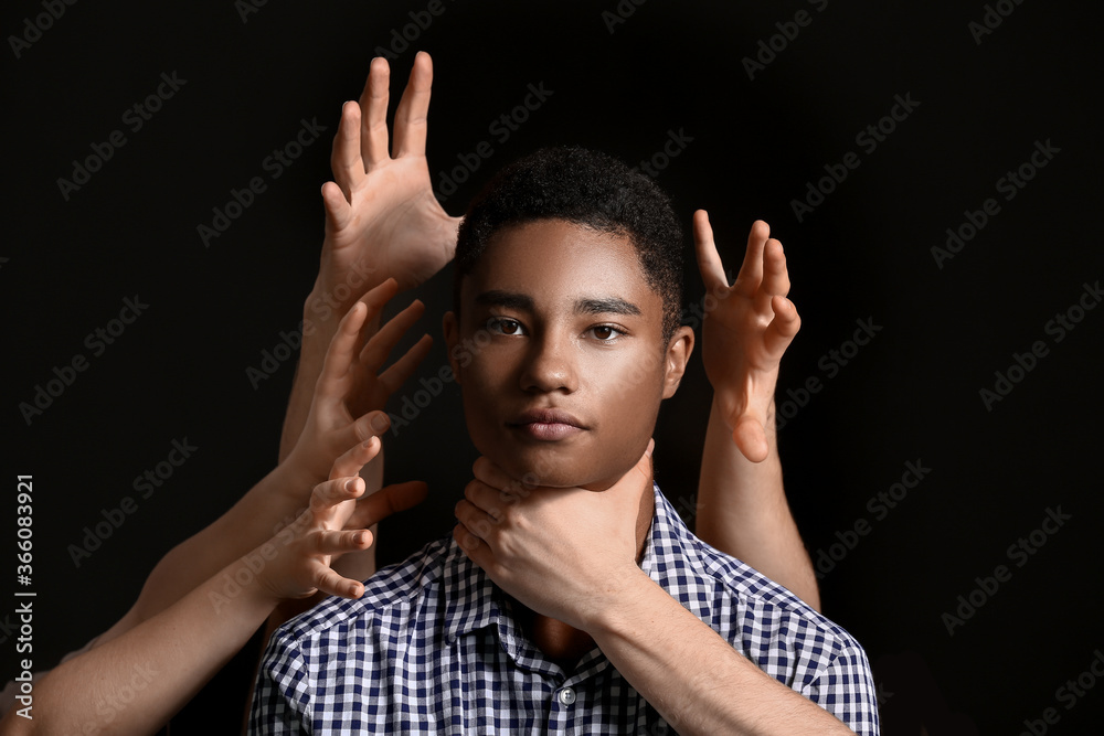 People strangling African-American teenage boy on dark background. Stop ...