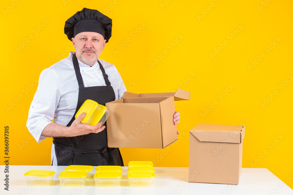 Chef cook man unpacks boxes. Cook takes out kitchen equipment. Plastic ...