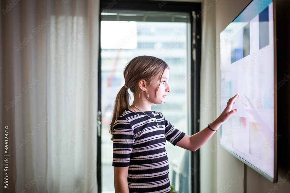 Girl touching digital screen of smart TV at modern home Stock Photo ...