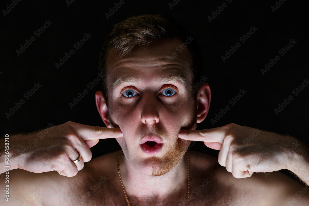 Young man shaving his beard. He shaved off half the bristles against a ...