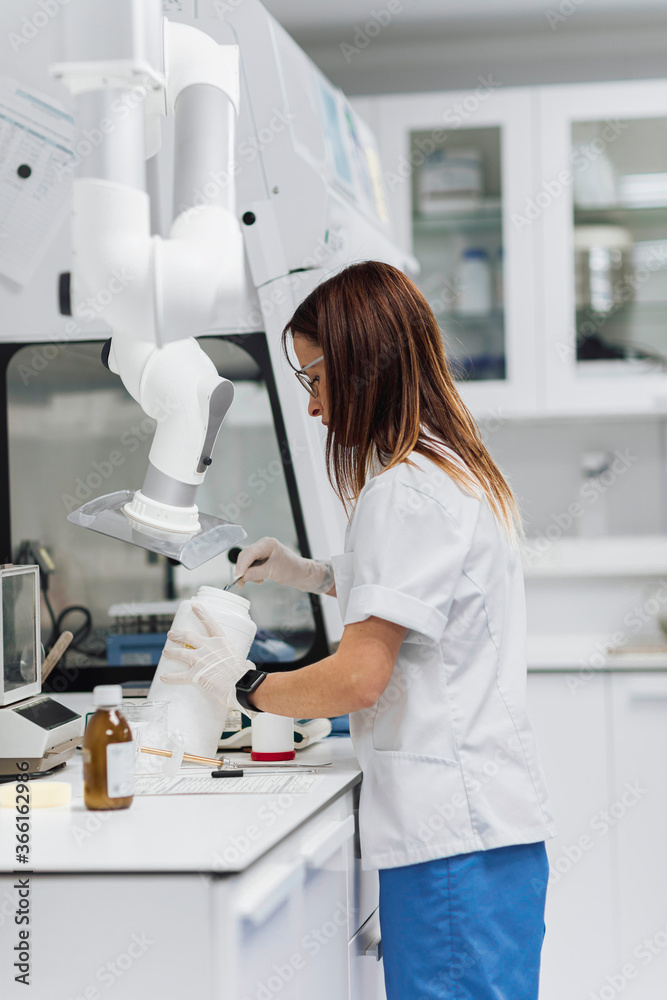 Female healthcare worker with long brown hair removing something from ...