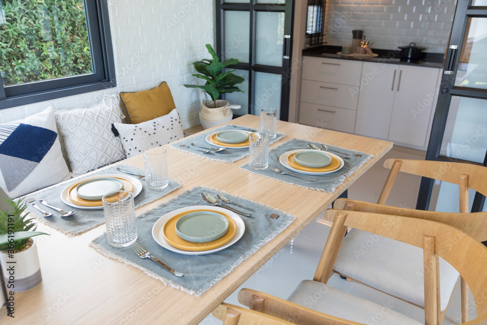 table set on table with yellow plate setting in modern style dining ...