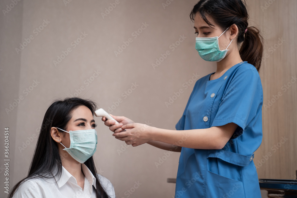 Asian medic nurse measure and check patient temperature from infrared ...
