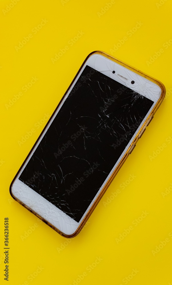 Broken smartphone on yellow background. Broken display to be repaired ...
