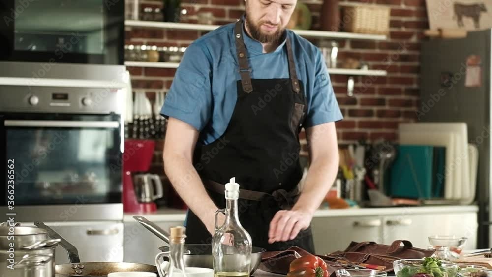 Video Stock professional chef in an apron uniform stands in the kitchen ...
