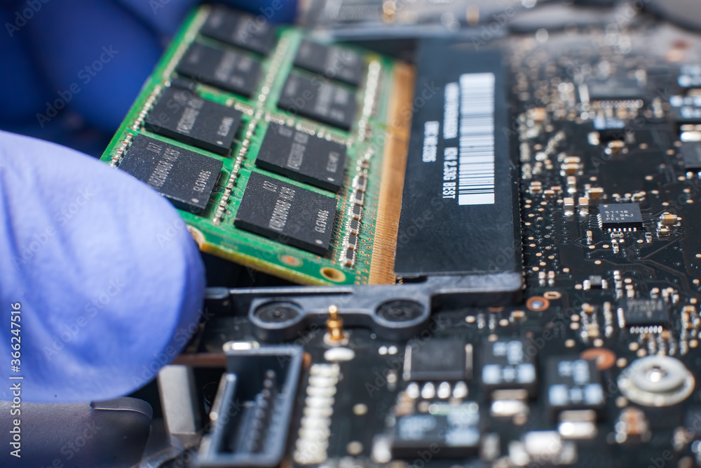 Service engineer install new RAM memory chips to the laptop. Repairing ...