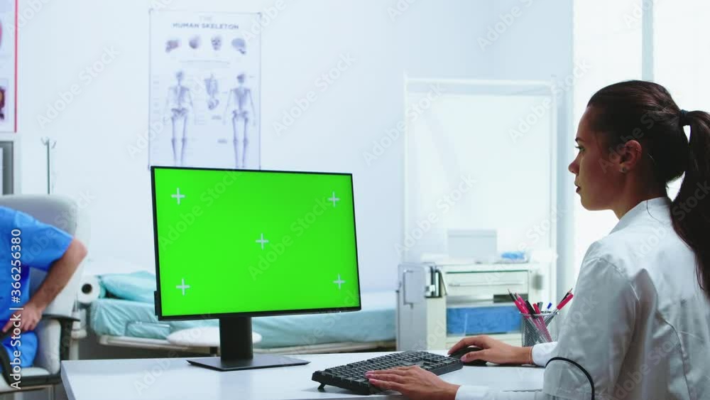 Vidéo Stock Doctor using computer with green screen display in hospital ...