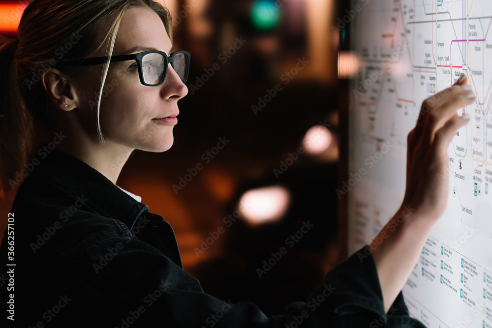 Digital monitor with public transport subway map. Female standing at ...