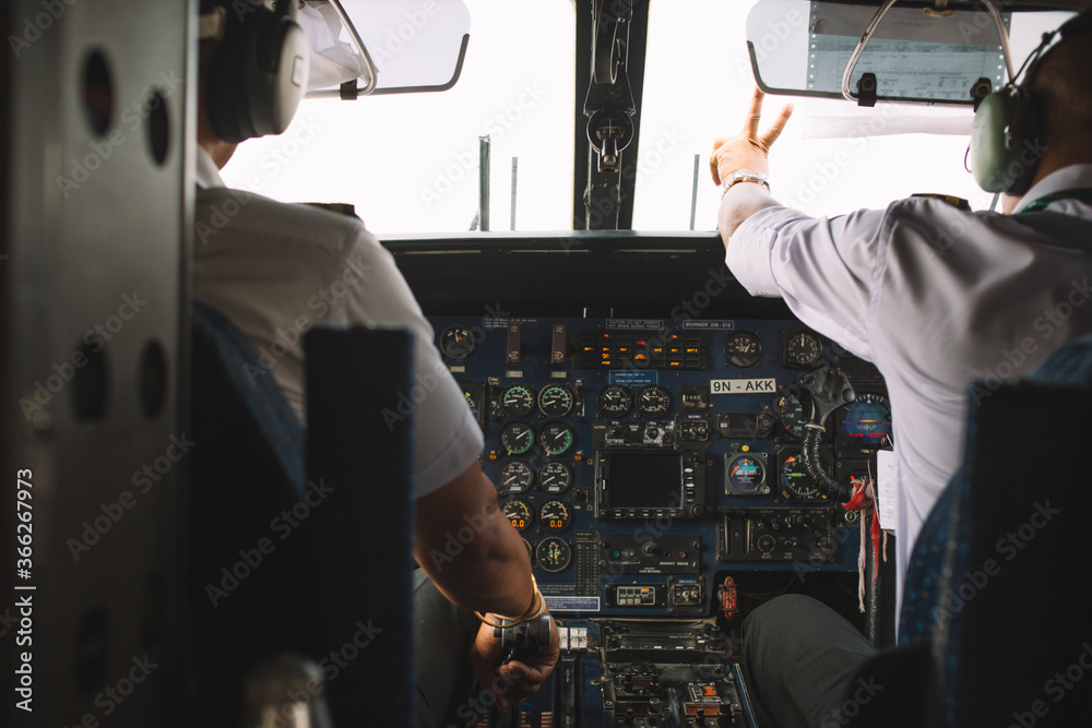 Back view of two men: pilot and copilot sitting at control cockpit ...
