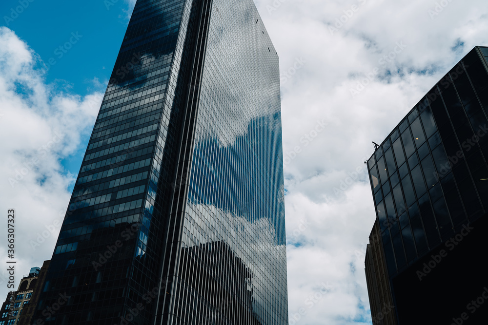 Tall modern skyscraper with crystal exterior and sky reflexion in ...