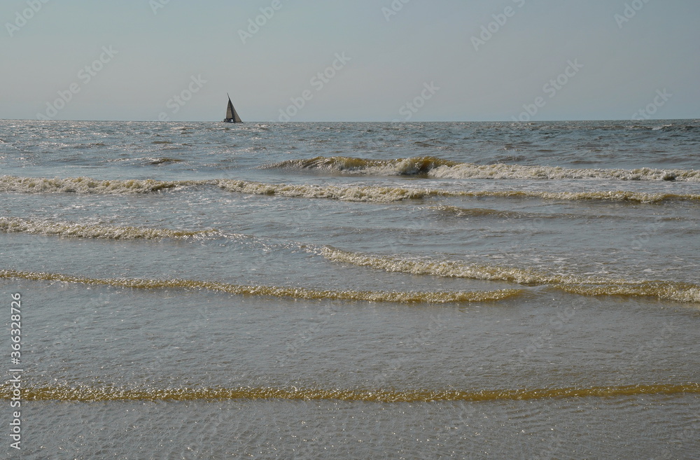 Das aufgewühlte Meer mit viele Wellen vor dem blauen Himmel. Nur am ...