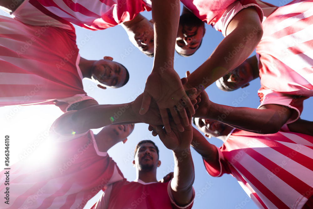 Multi ethnic team of male football players training at a sports field ...