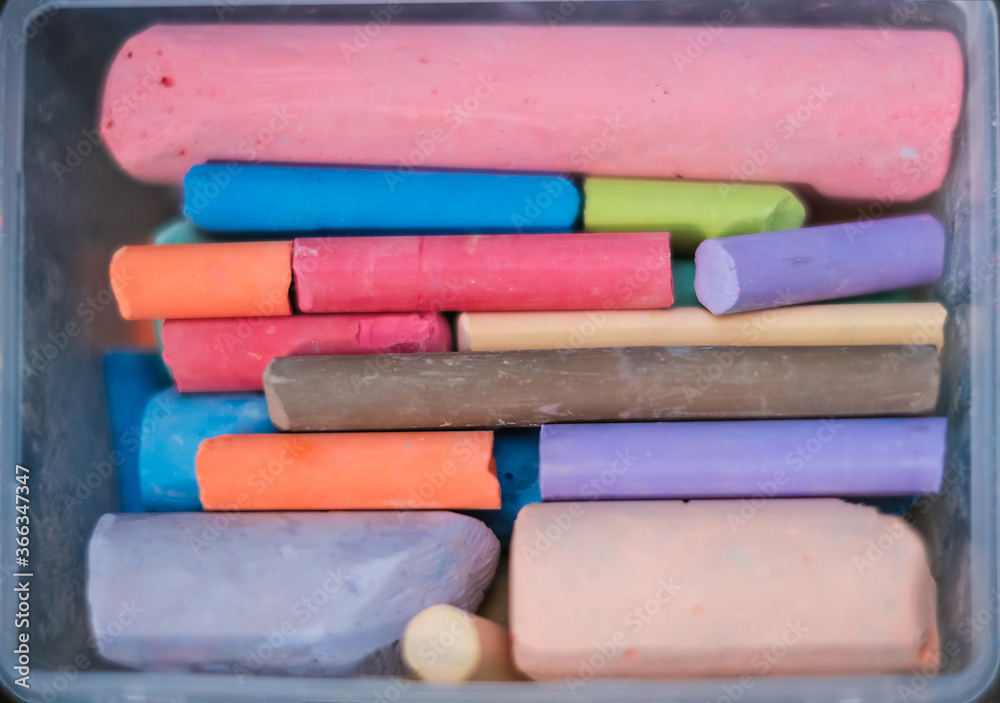 Multi-colored crayons of different lengths and thicknesses lie in a ...