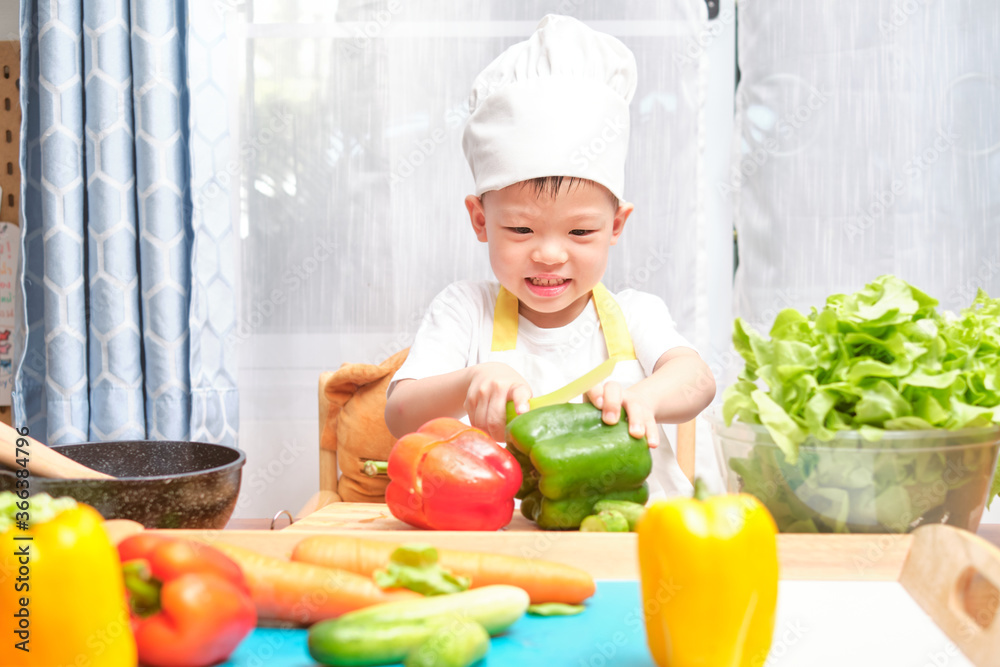 Cute happy smiling Asian little boy child wearing chef hat and apron ...