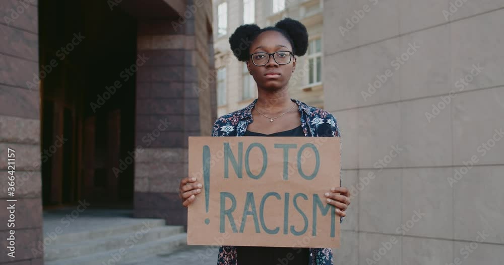 Portrait of african american girl looking to camera while holding ...