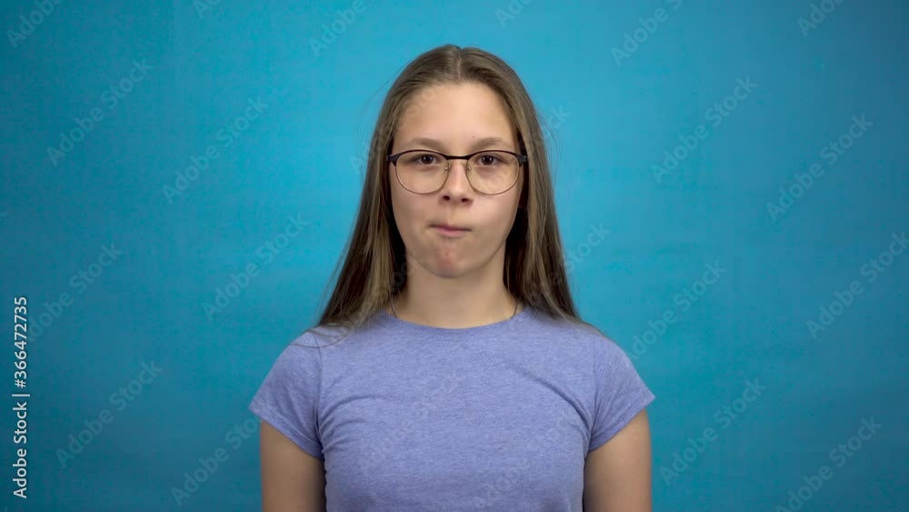 Teenage Girl With Braces On Her Teeth Eats Celery On A Blue Background