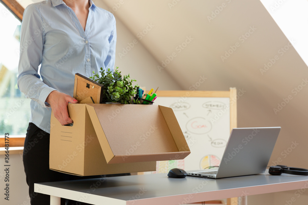 Beautiful business woman carrying a box of office stuff. New work ...