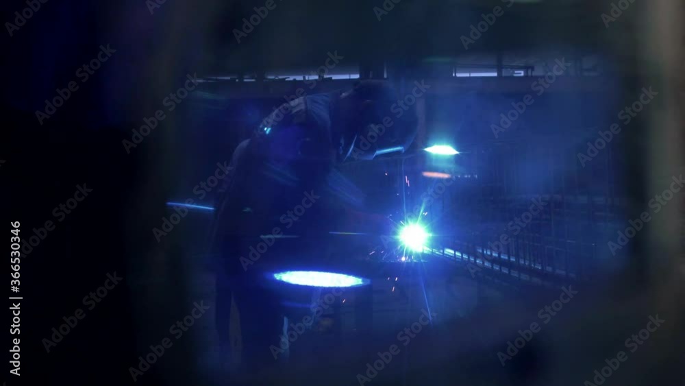 Professional welder is cooking metal. Reflection in the visor of the ...