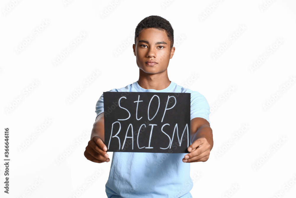 Sad African-American teenage boy with poster on light background. Stop ...