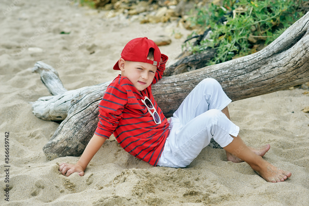 Portrait of a small boy in nature . A child model poses on a deserted ...