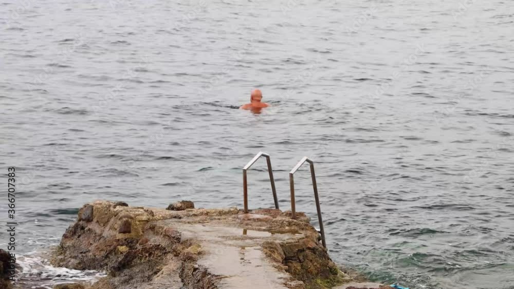 Footage of a bald man swimming in the ocean in Ibiza in Spain showing a ...