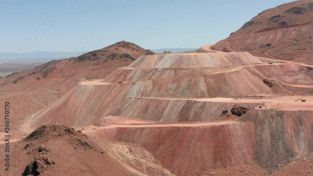 Aerial panorama view of the red stone quarry on a sunny day. A dump ...