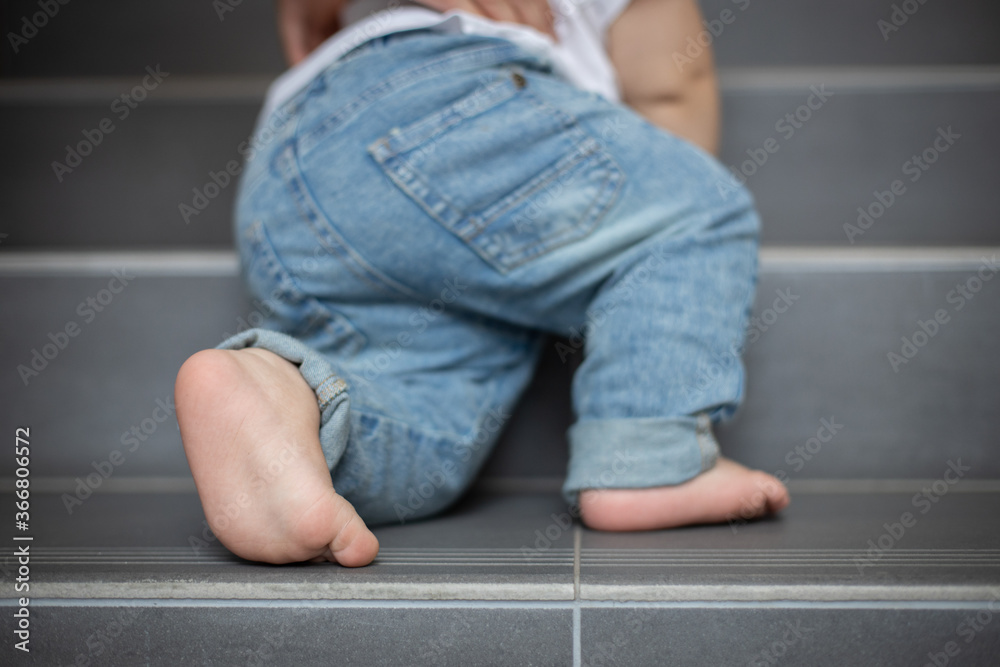 baby climbs the stairs, little feet on the steps, the first steps ...