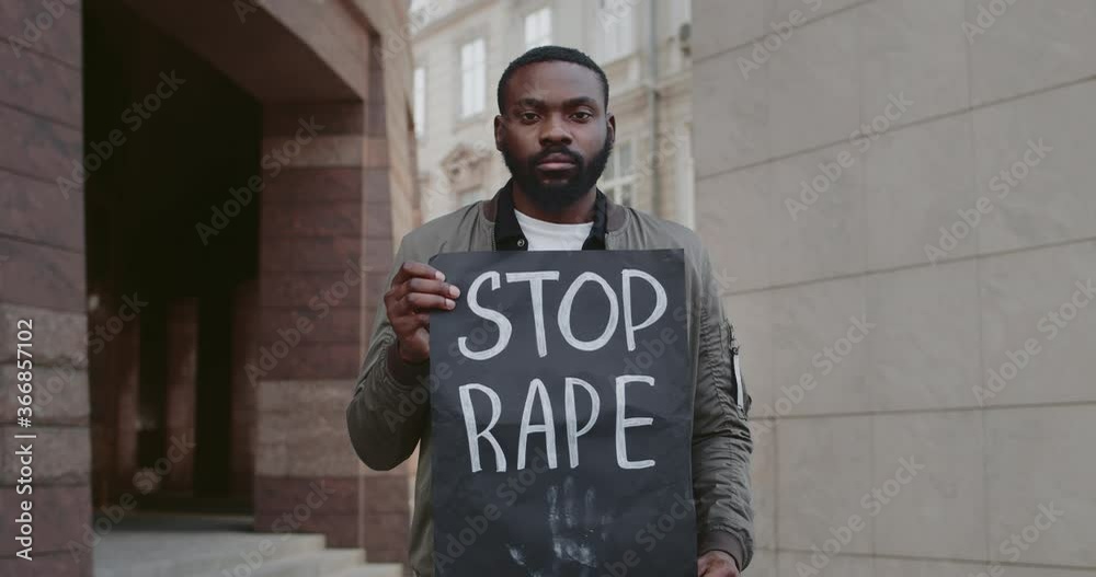 Portrait of african american guy holding carton with stop rape slogan ...